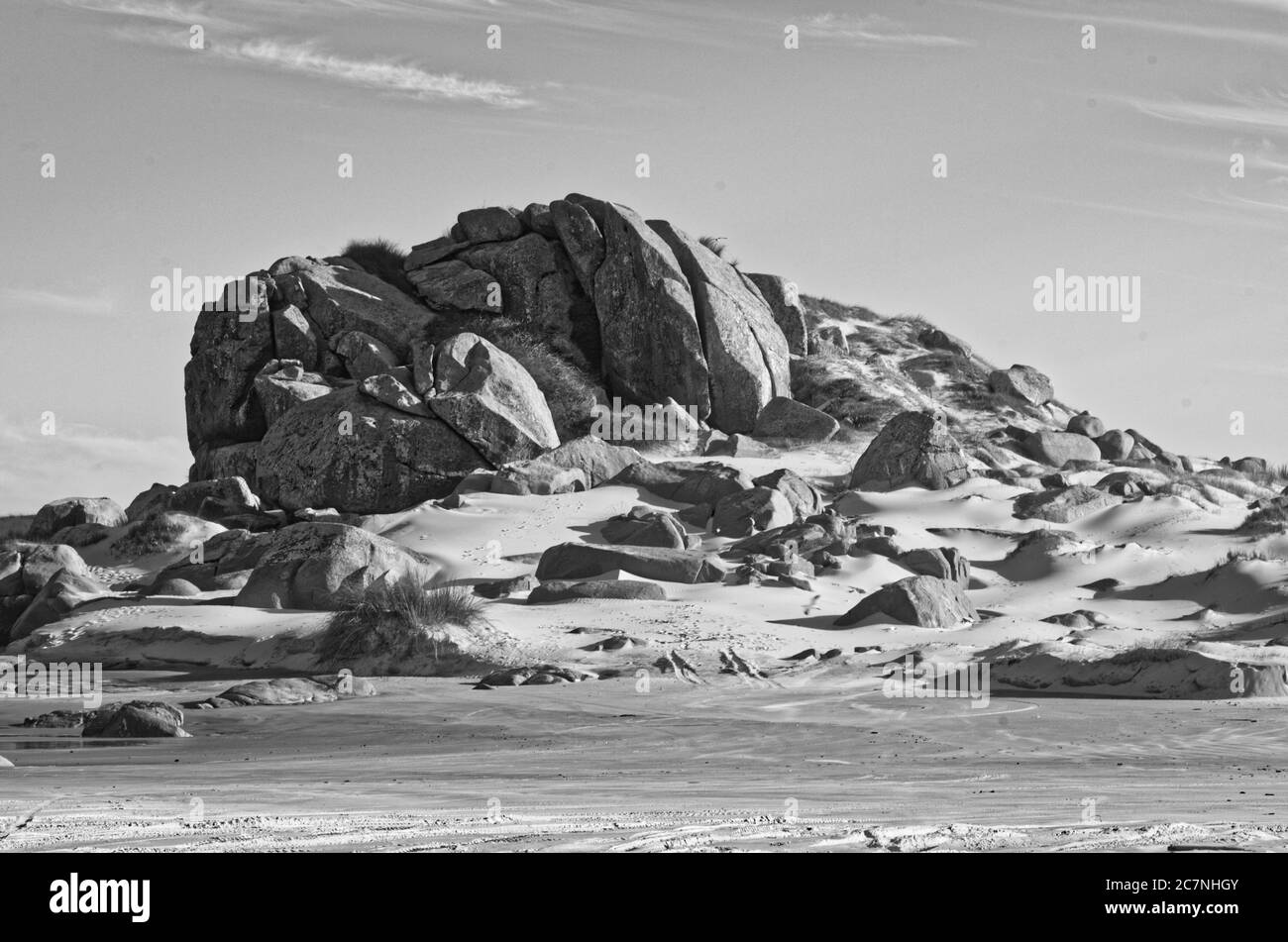 Grayscale shot of a big weathered rock and sand Stock Photo - Alamy