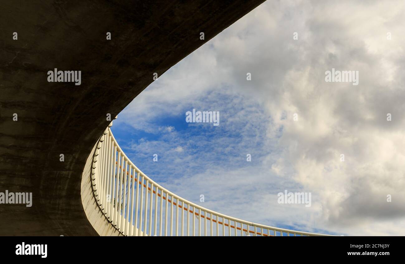 Looking up at the curve of a footbridge over the freeway Stock Photo ...