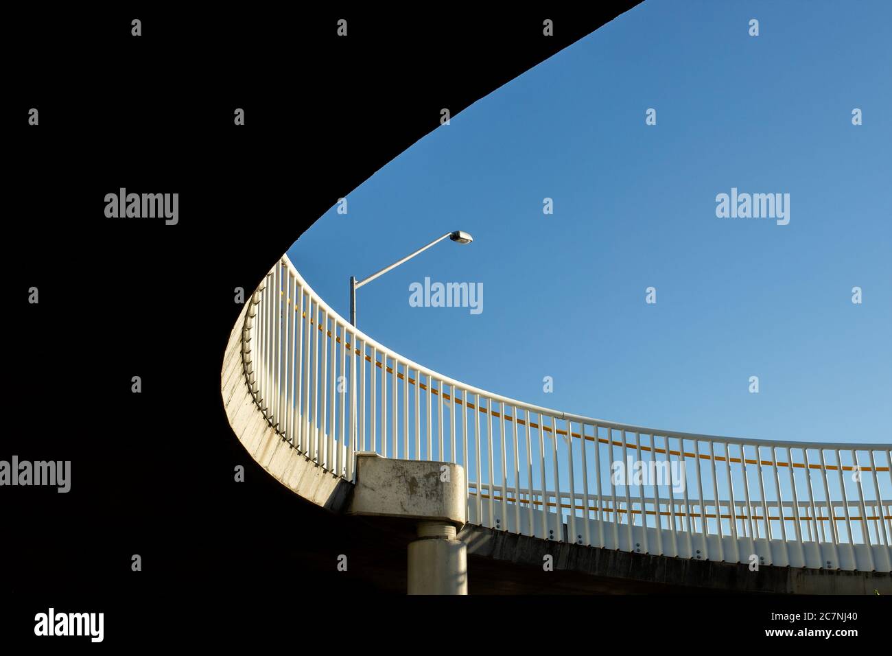 Looking up at the curve of a footbridge over the freeway Stock Photo ...