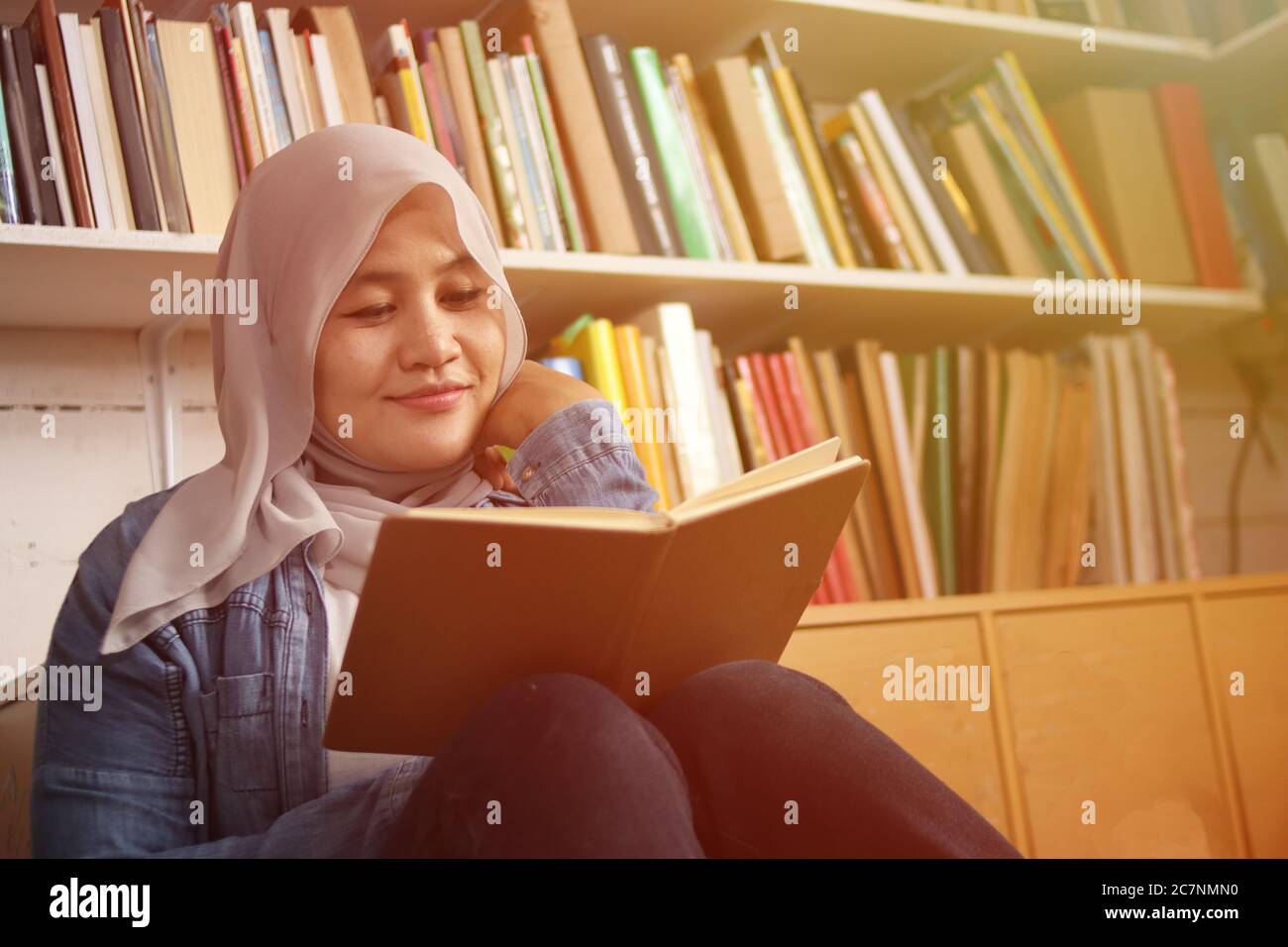Asian muslim woman wearing hijab reading book in library, educational ...