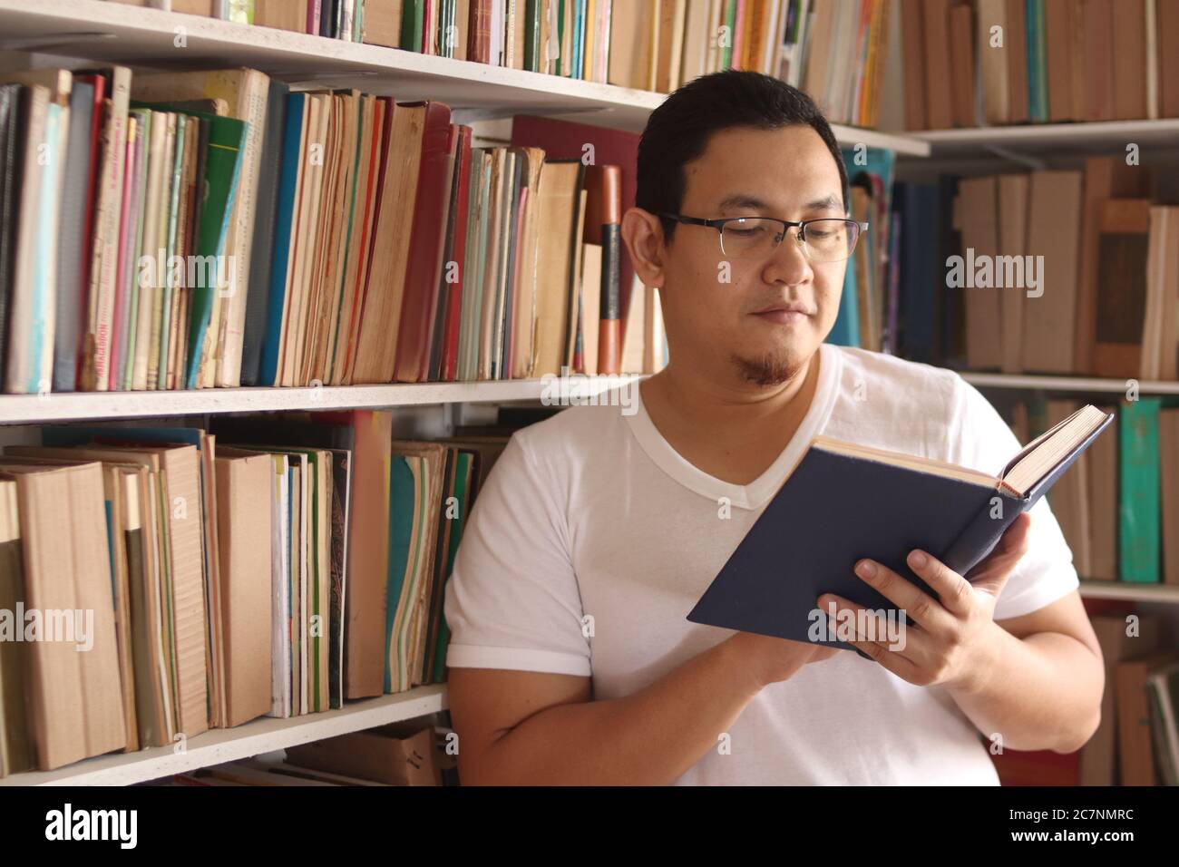 Asian man reading book in library, educational concept. Happy smiling ...