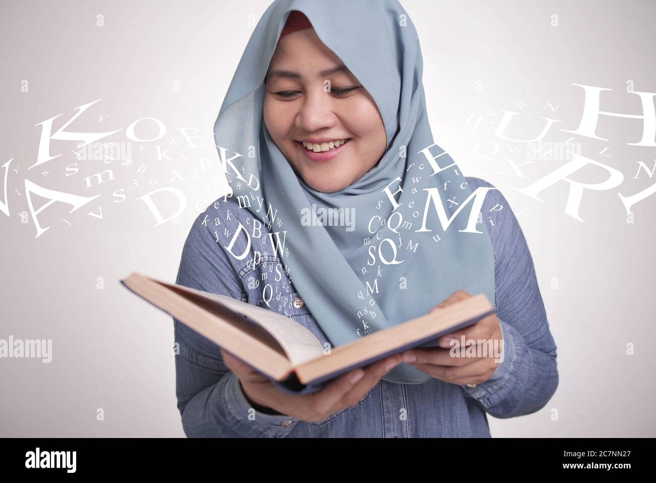 Portrait of young muslim business woman wearing hijab reading book and ...