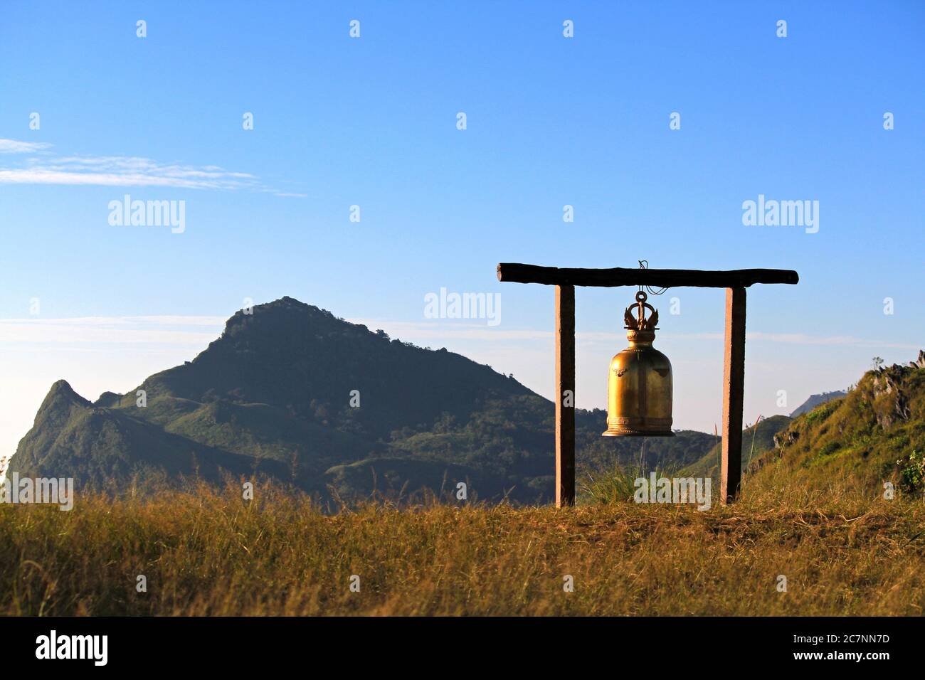 Golden bell hanging from a wooden structure in the mountains Stock ...