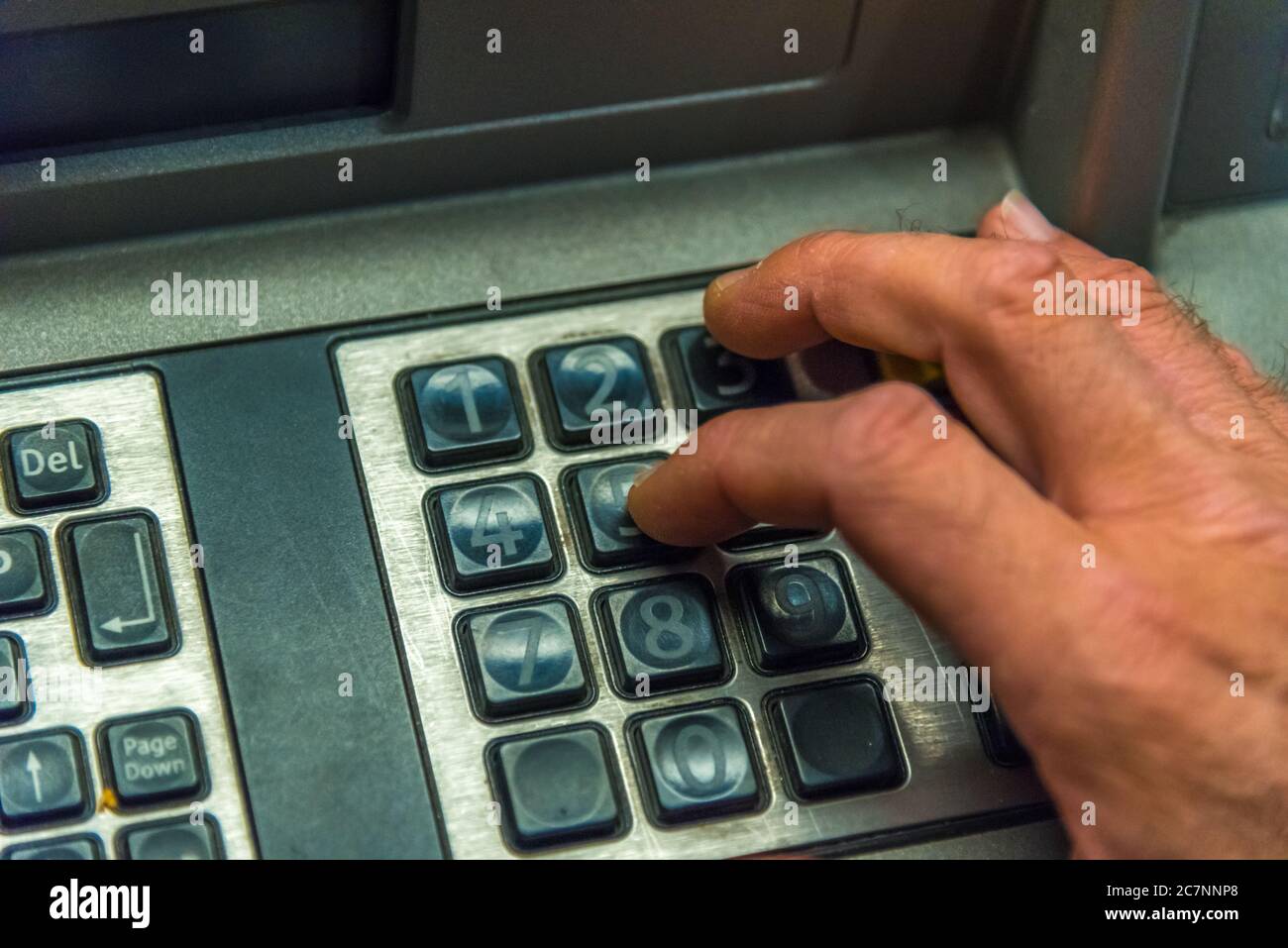 Closeup shot of an adult man pushing buttons at the numeric keypad ...