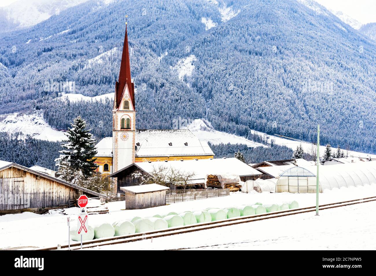 Small rural village surrounded by snow mountains hi-res stock ...