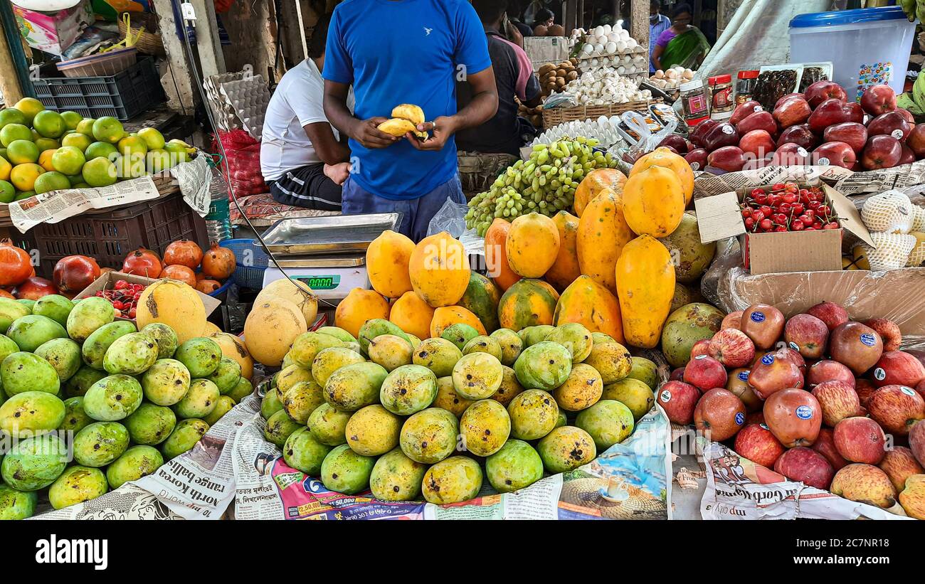 Ripe mangoes with fresh apples and papaya on sale at a local fruit shop ...