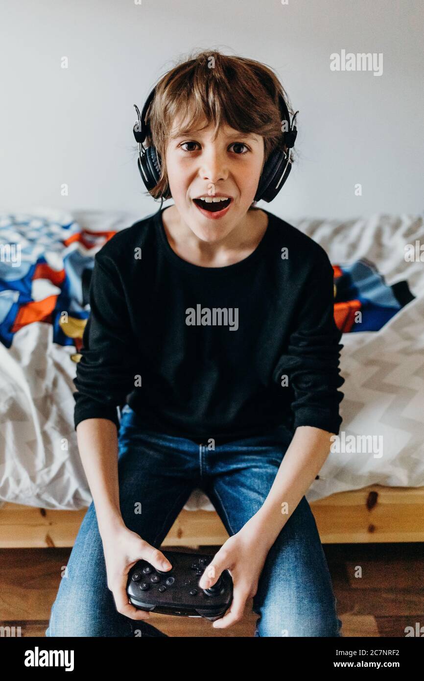 White young boy playing video games in the bedroom - the concept of ...