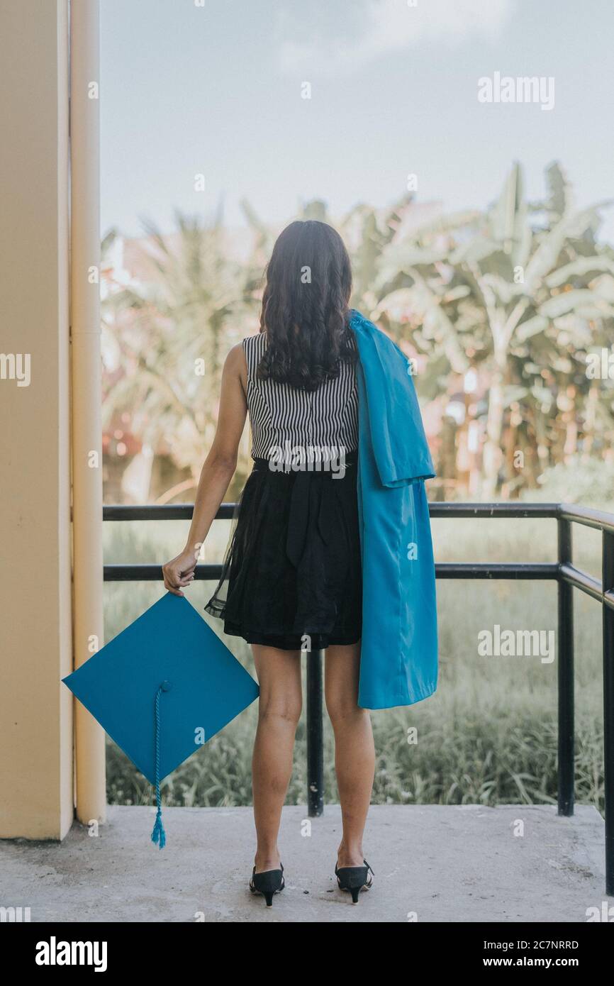 Potrait of a Filipino Woman Holding her Graduation Cap and Gown Stock ...