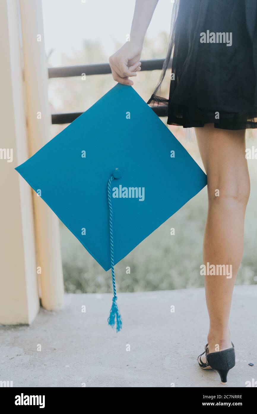 Potrait of a Filipino Woman Holding her Graduation Cap and Gown Stock ...