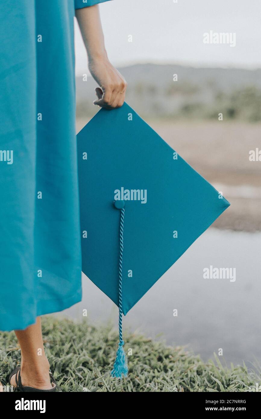 Potrait of a Filipino Woman Holding her Graduation Cap and Gown Stock ...