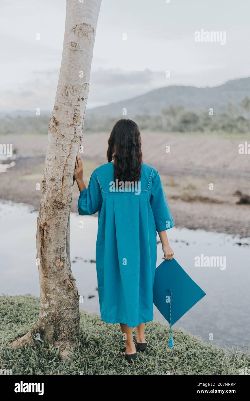 Potrait of a Filipino Woman Holding her Graduation Cap and Gown Stock ...