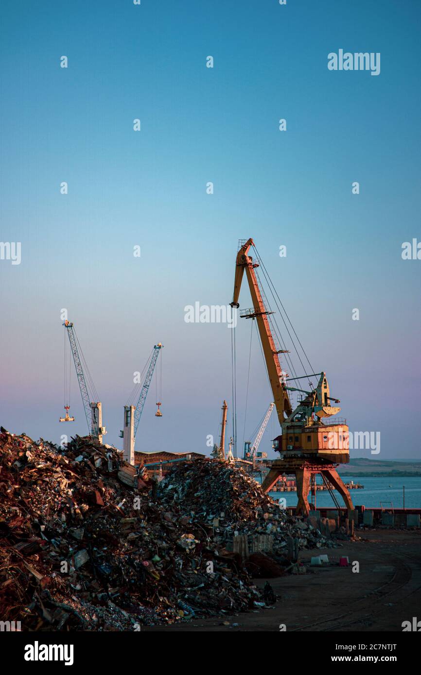 Garbage pile in trash dump or junkyard, metal crane unload garbage ...