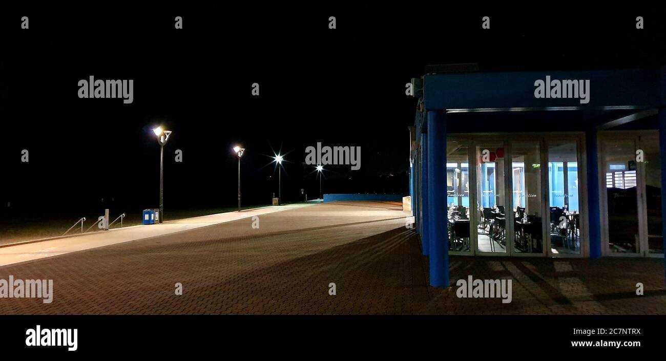 Building by the beach captured at night with the switched on city ...