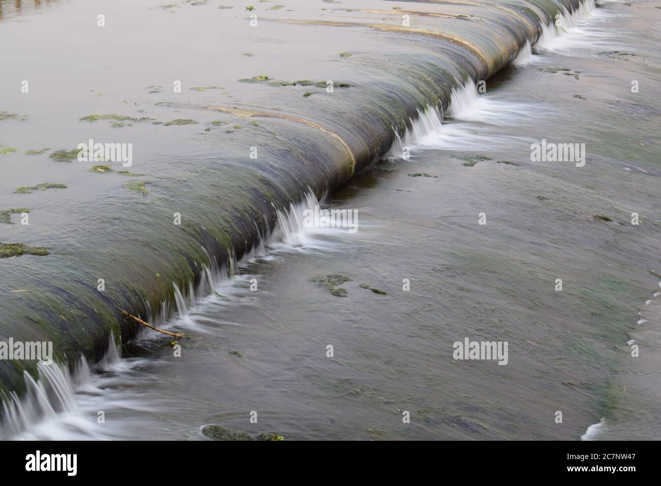 Water flowing through the mossy dam Stock Photo - Alamy