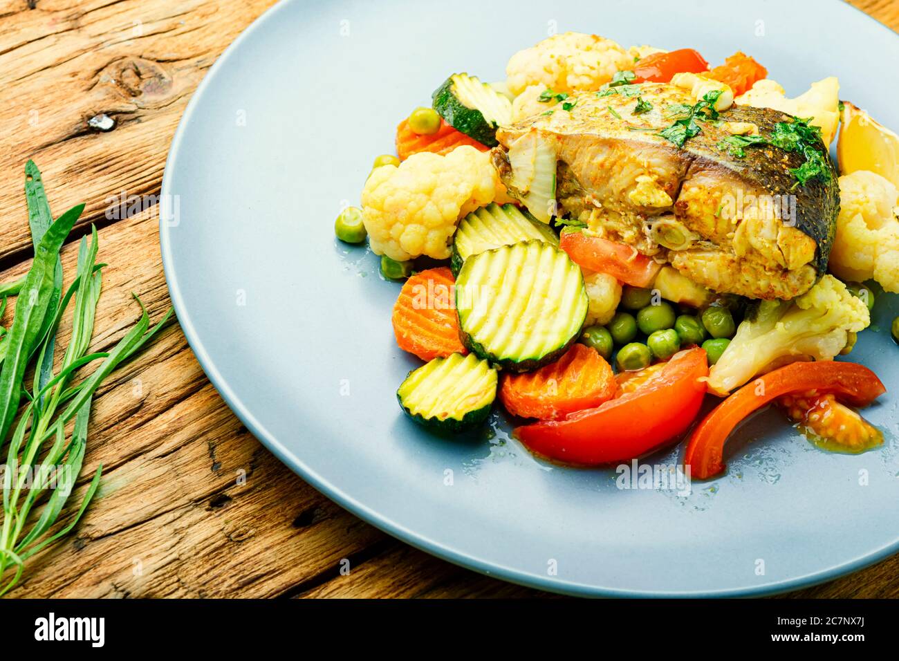 Baked fish steaks with grilled vegetables on plate Stock Photo - Alamy