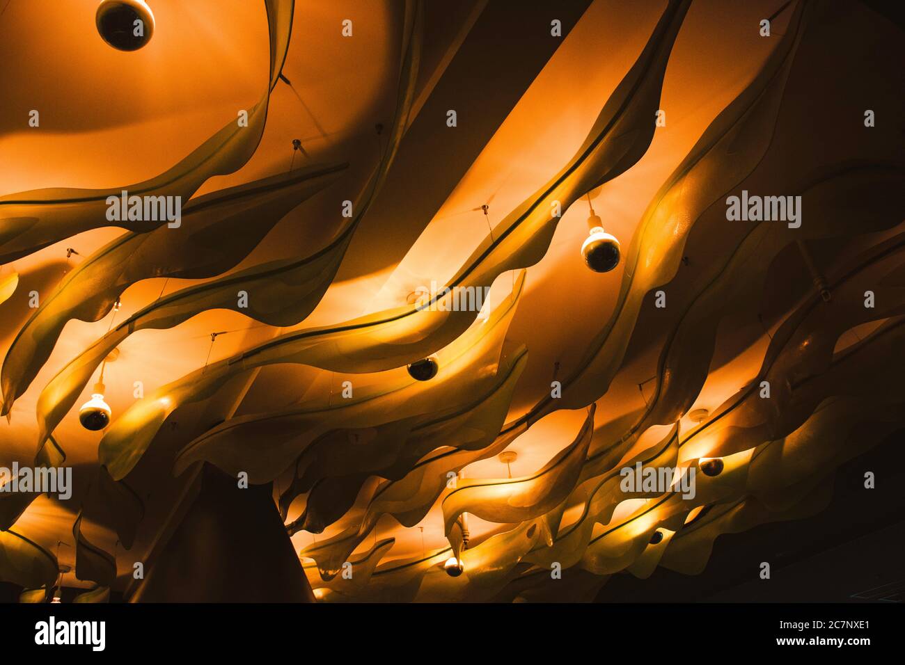 Abstract Wavy Yellow Ceiling Decoration with Circular Lights Stock ...