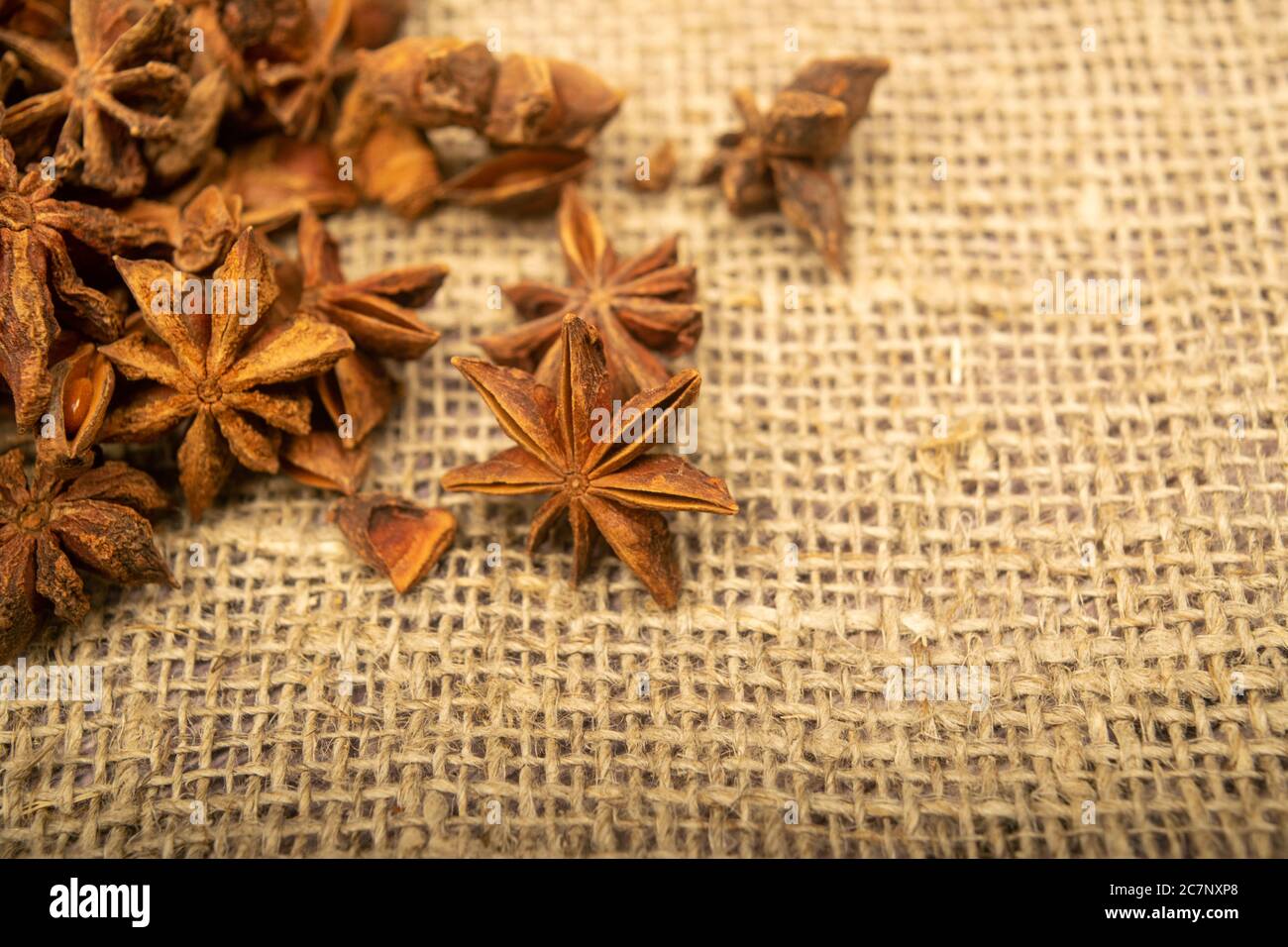 A pile of star anise on a background of burlap with a rough texture ...