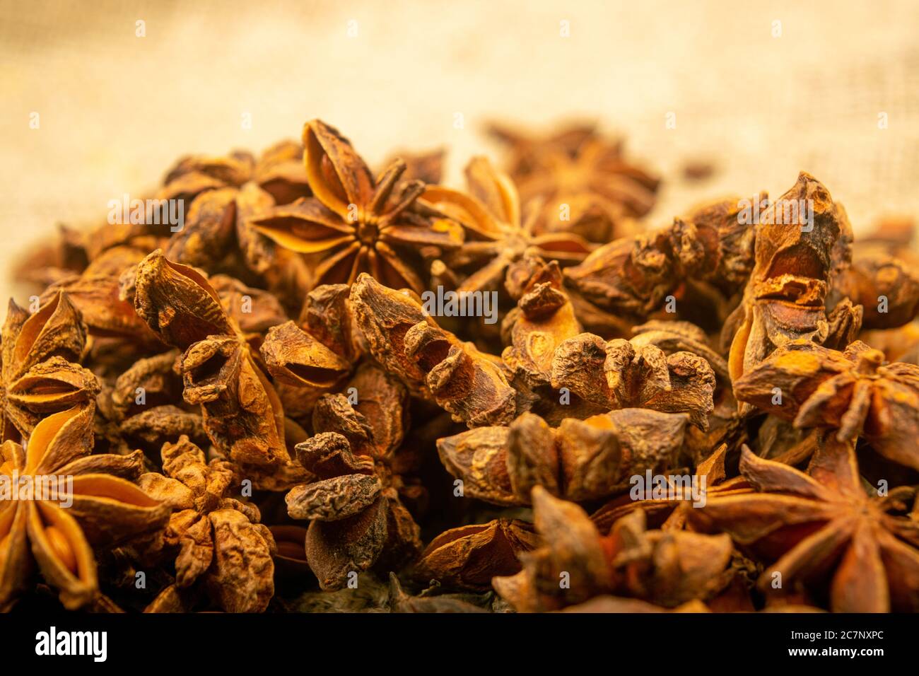 A pile of star anise on a background of burlap with a rough texture ...