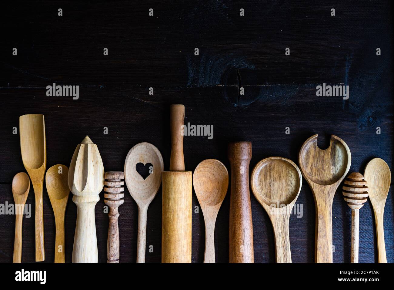 Varieties of kitchen wooden spoons in a frame on wooden background with ...