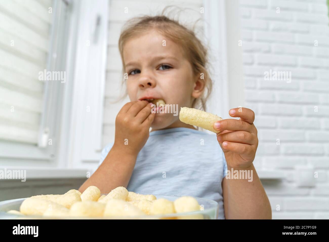 child eating corn sticks at the kitchen table Stock Photo - Alamy