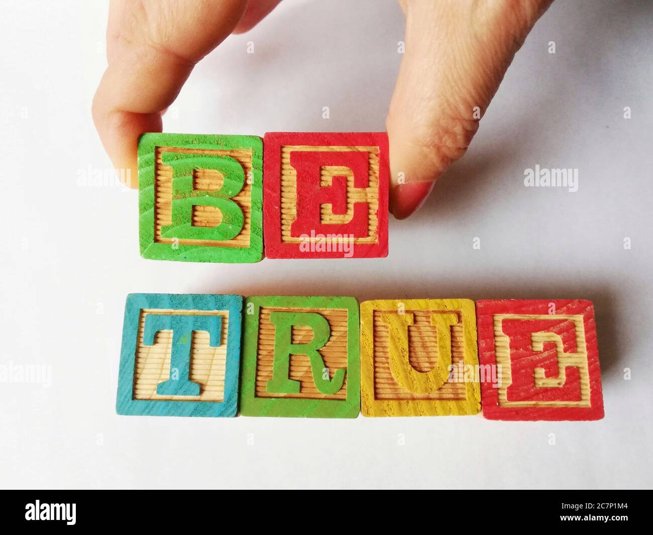 Closeup of colorful cubes spelling the word "be true" on a white ...