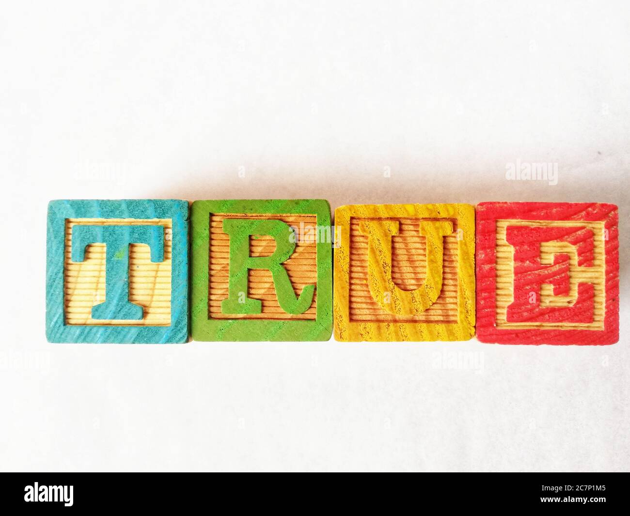 Closeup of colorful cubes spelling the word "true" with a white ...