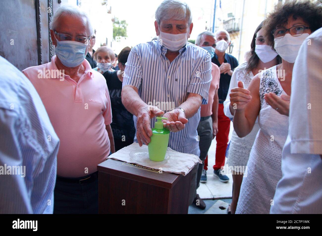 The faithful before entering the church put on their hands a sanitizing ...