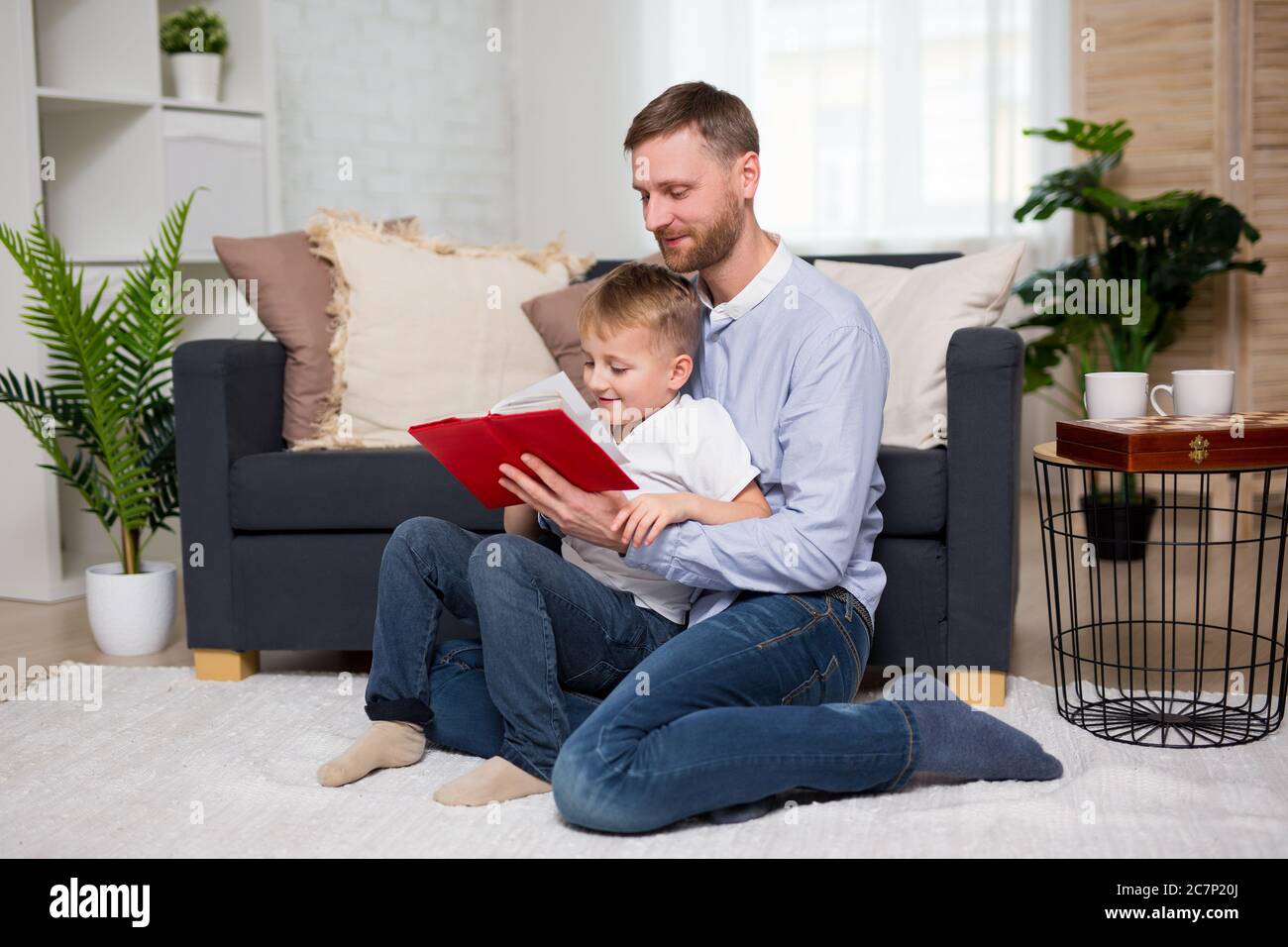 young father reading book to his little cute son at home Stock Photo ...