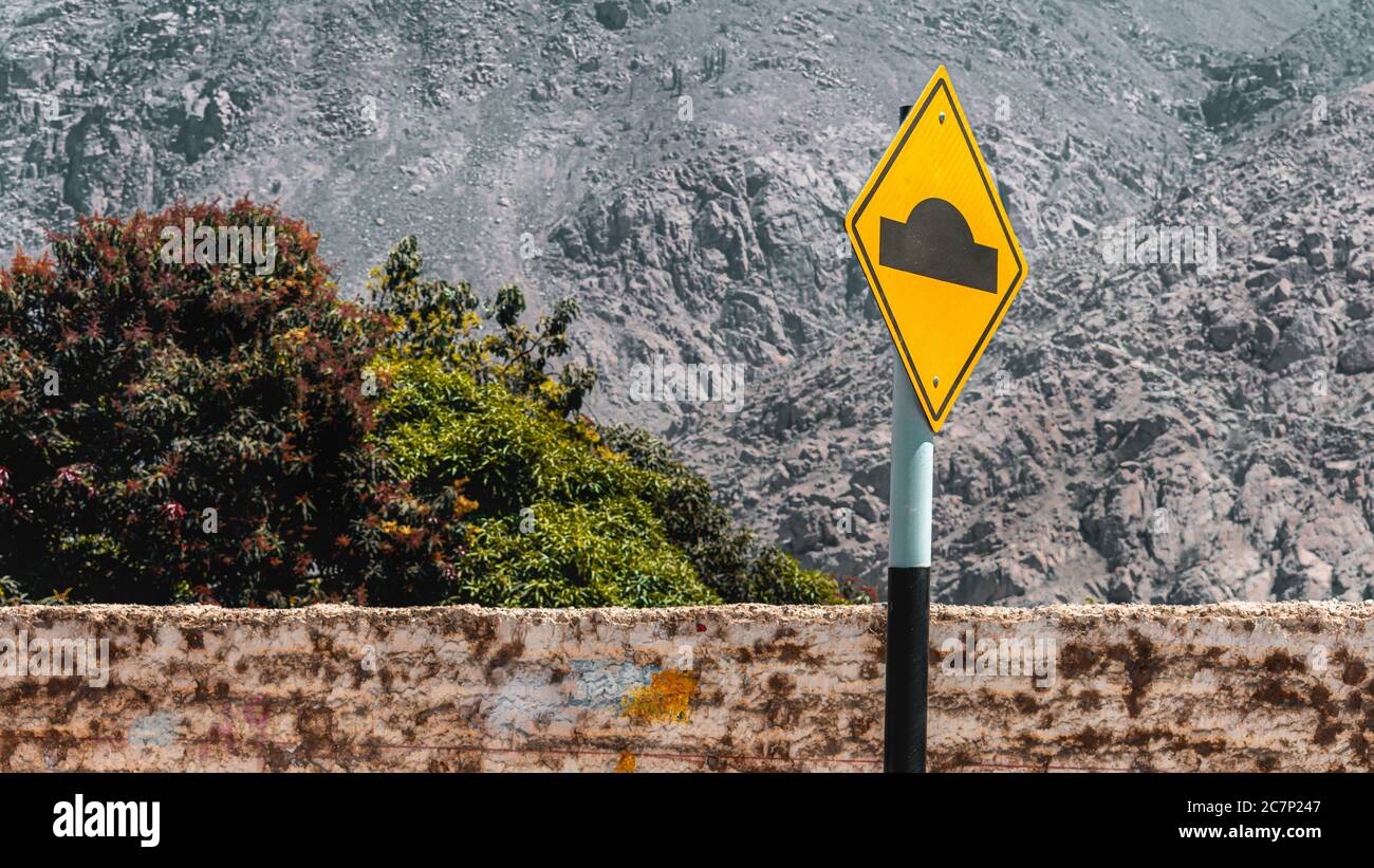 Yellow road sign with trees and rocky mountains in the background Stock ...