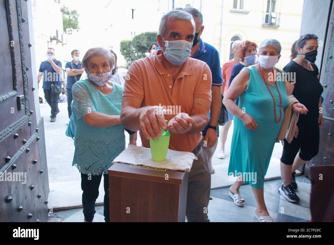 The faithful before entering the church put on their hands a sanitizing ...