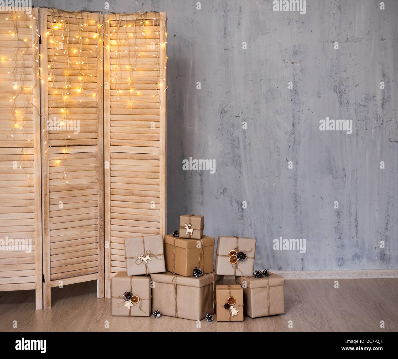 heap of christmas gifts and folding screen with lights - copy space ...