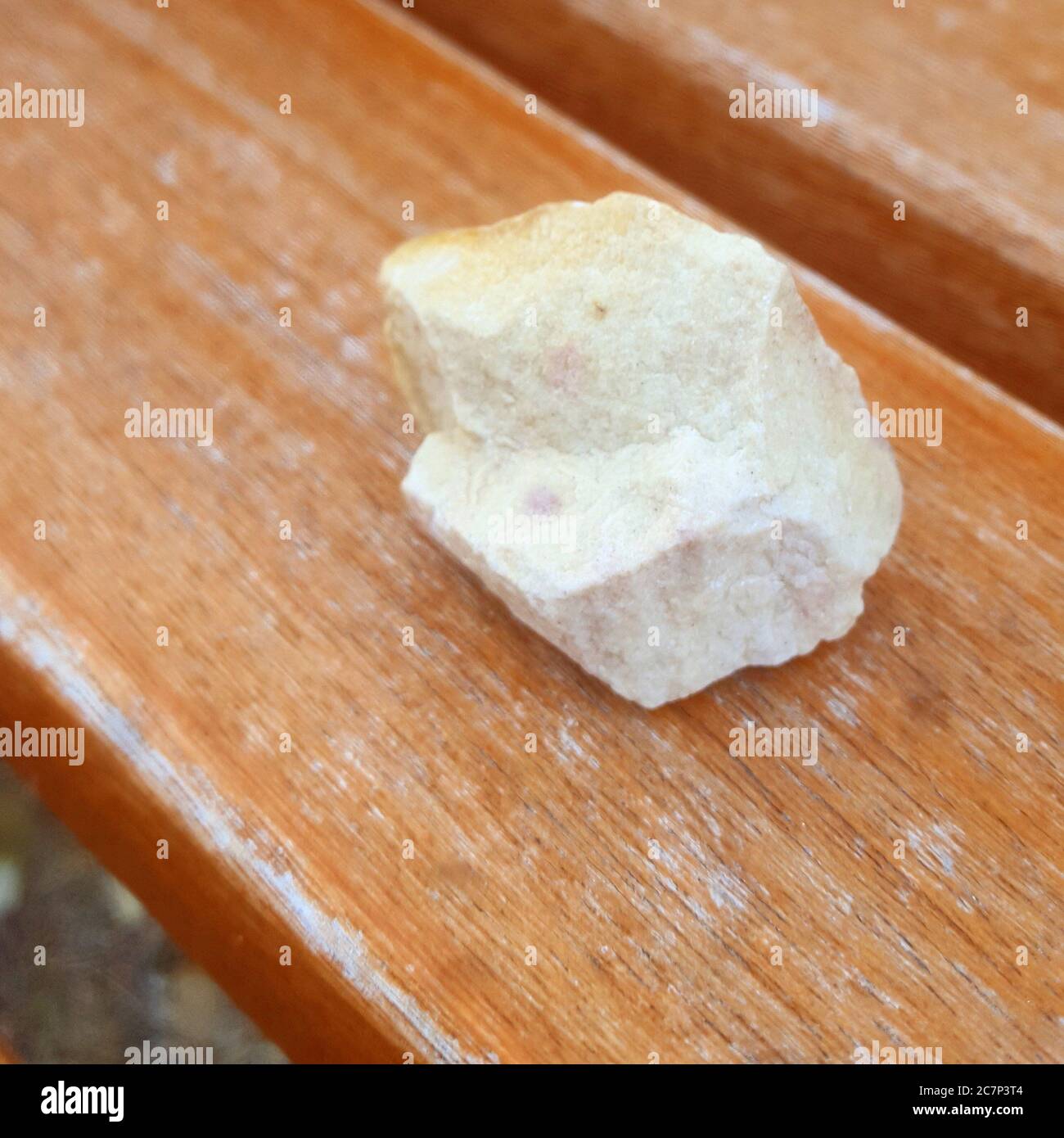 White natural stone on a wooden bench in a park Stock Photo - Alamy