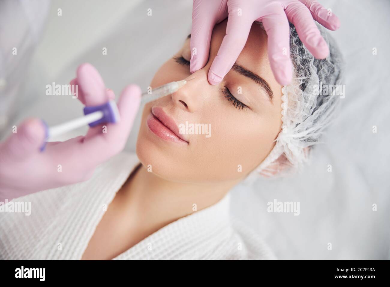 Calm female patient undergoing injectable beauty procedure Stock Photo ...