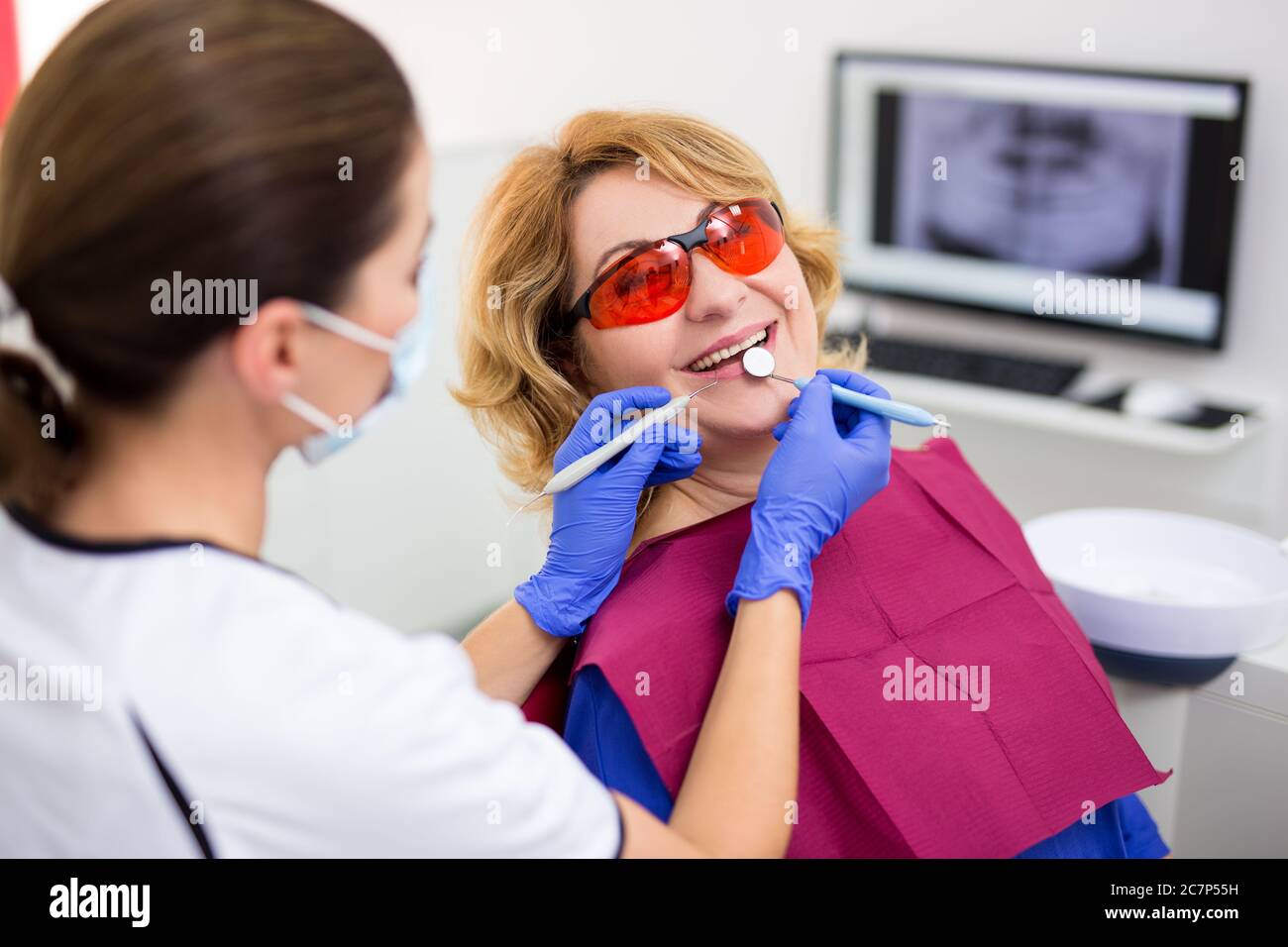 dentist working with happy female patient at modern clinic Stock Photo - Alamy