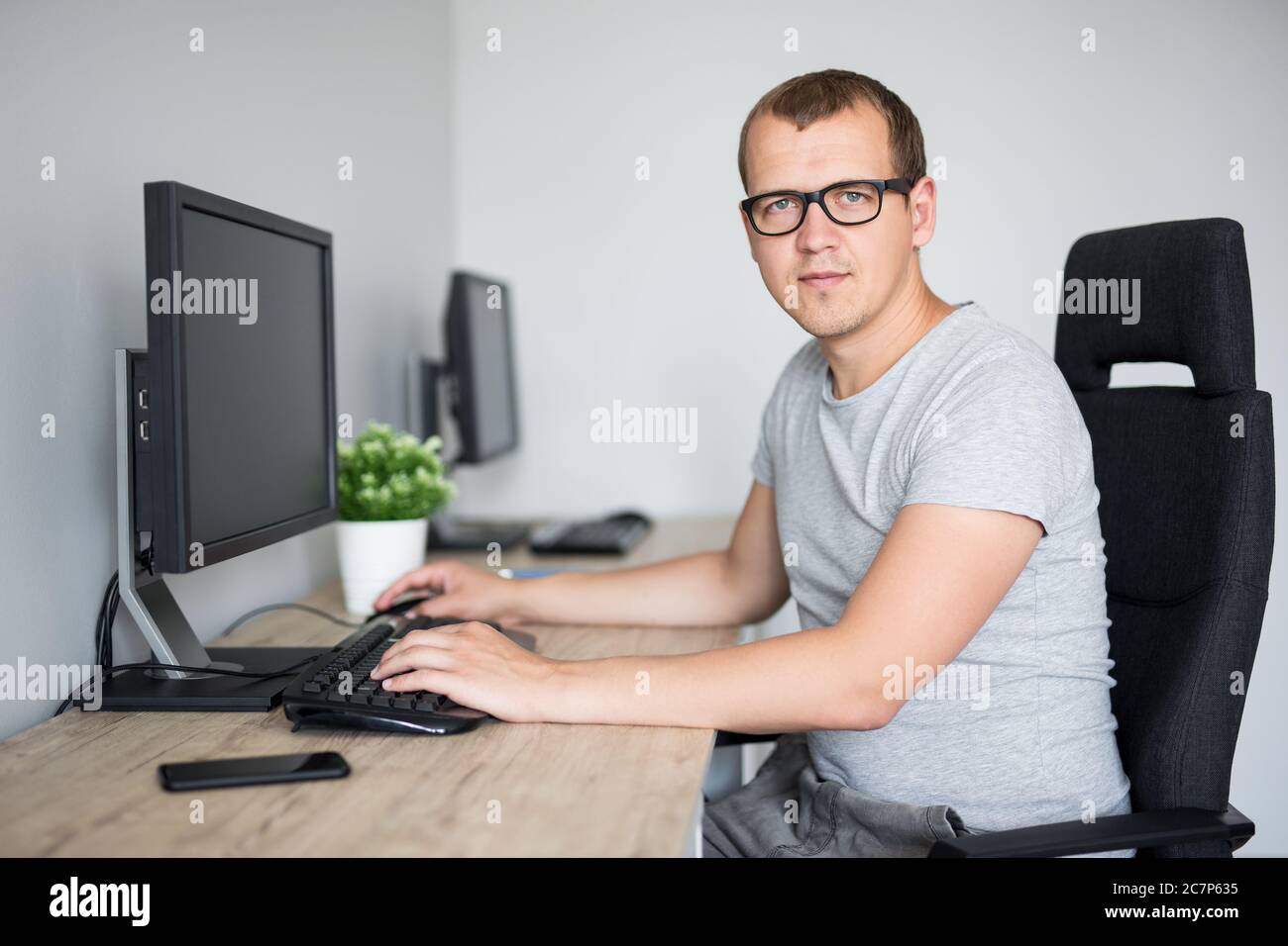 portrait of young handsome man using computer in modern office Stock ...