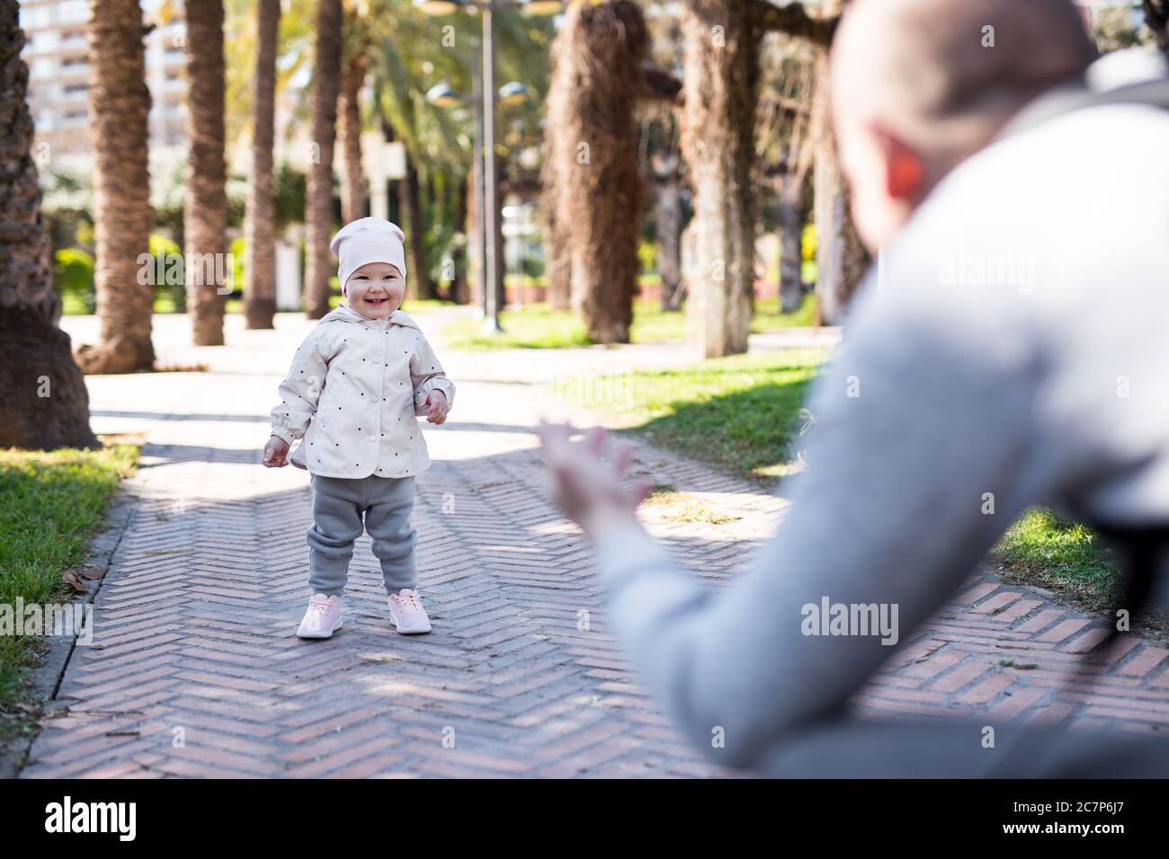 first steps concept - little baby girl learning to walk with father in ...