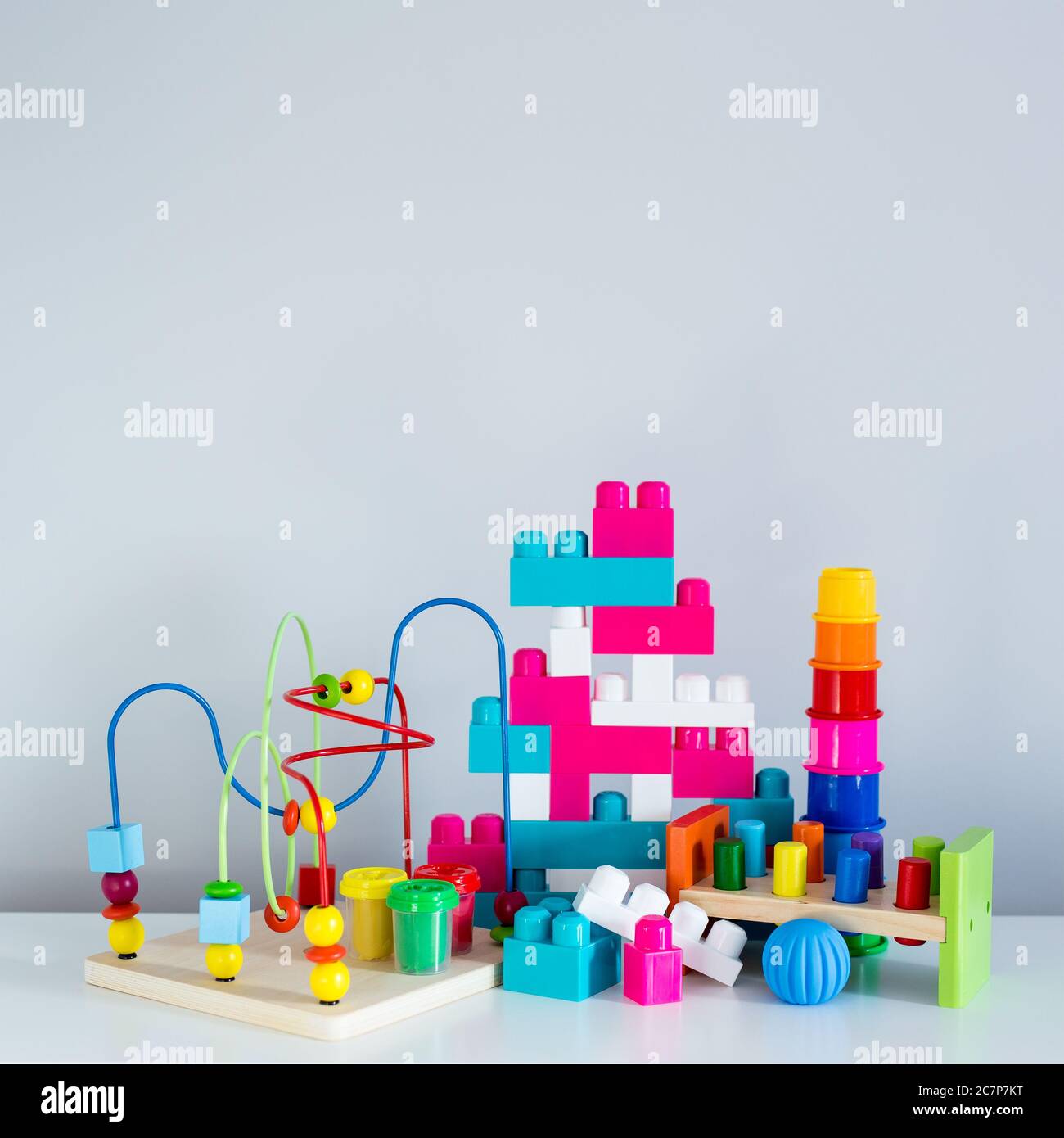 collection of colorful toys and constructor bricks over white wall ...