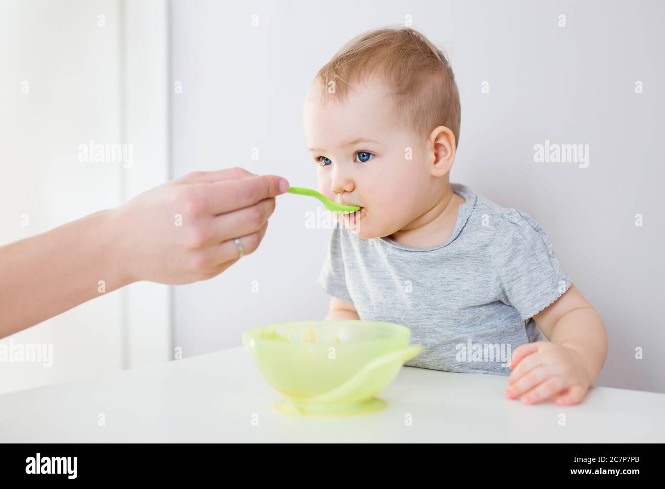 portrait of cute little girl eating from plastic spoon Stock Photo - Alamy