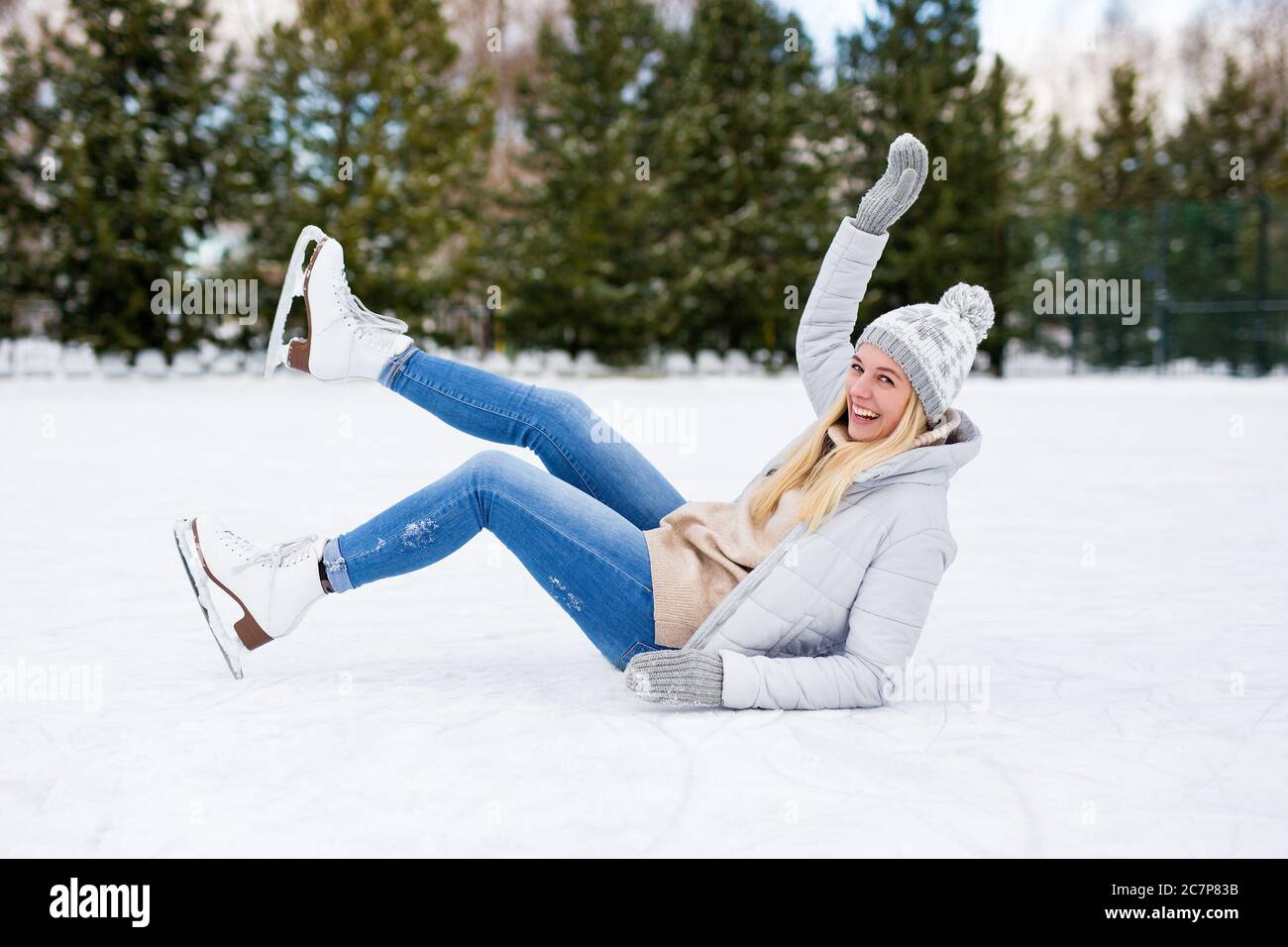 funny girl falling down while ice skating at winter rink Stock Photo ...