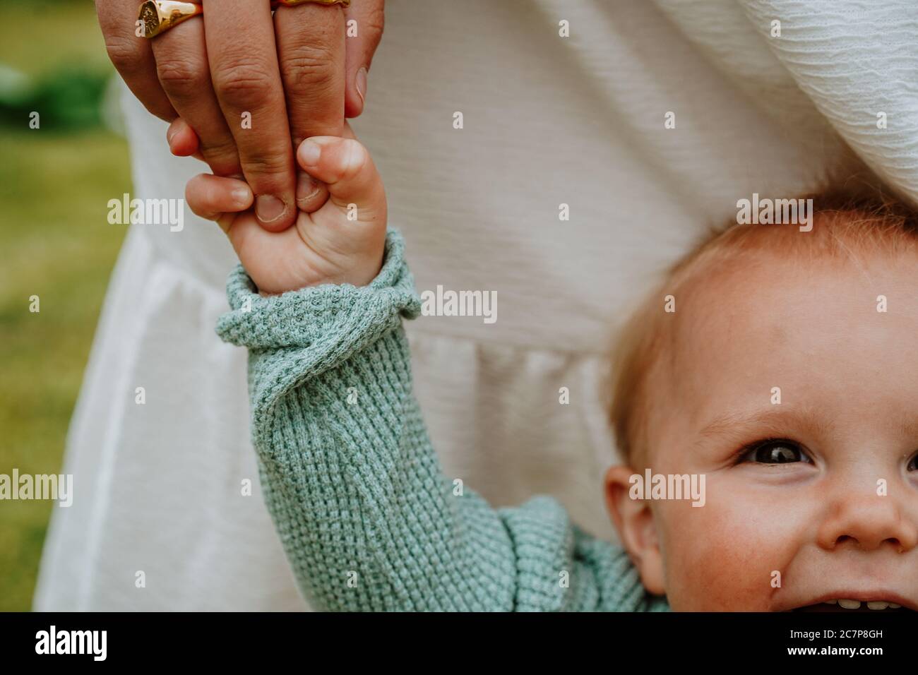 Young toddler holding mum's hand Stock Photo - Alamy
