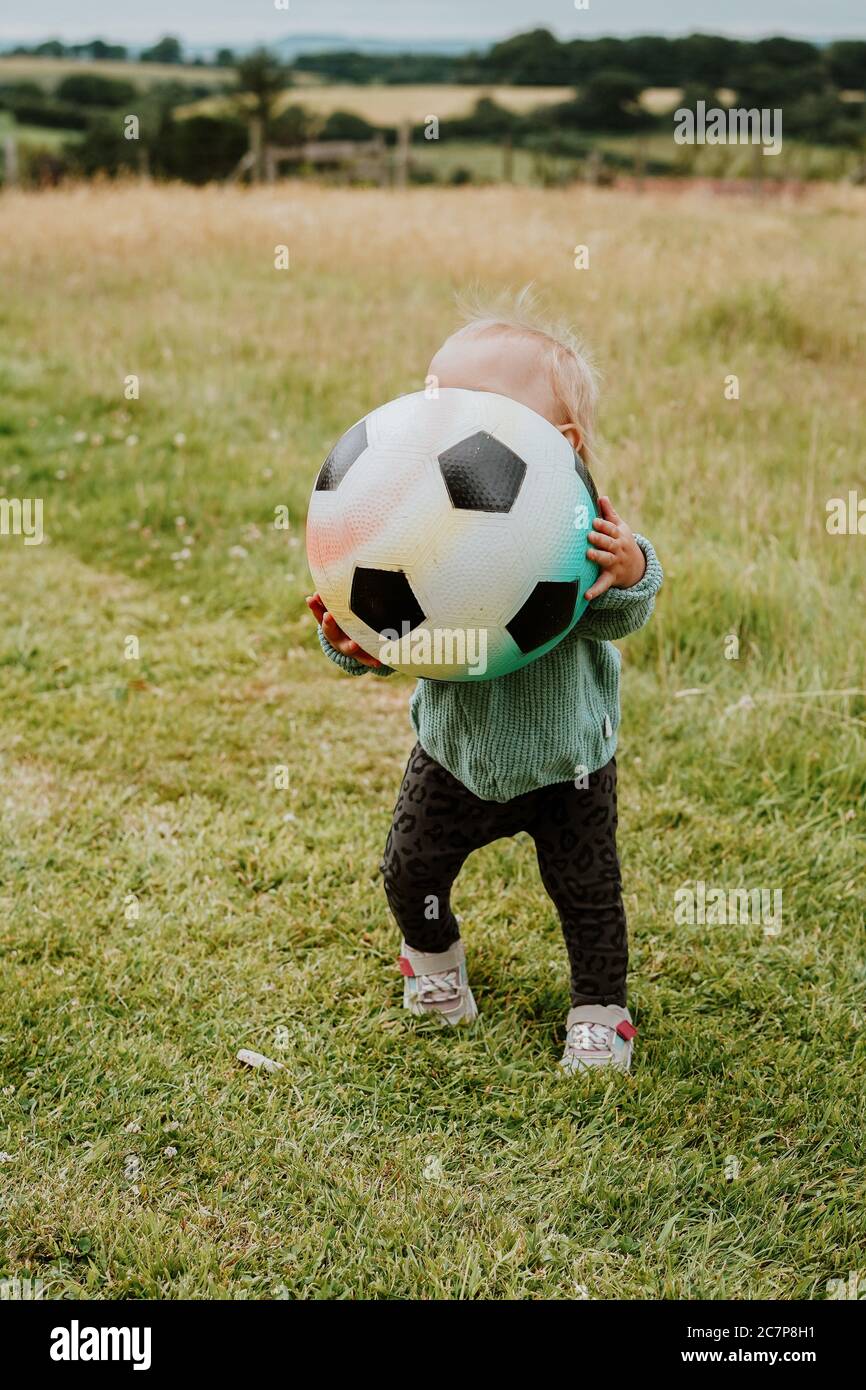 Boy toddler playnig football in field Stock Photo - Alamy