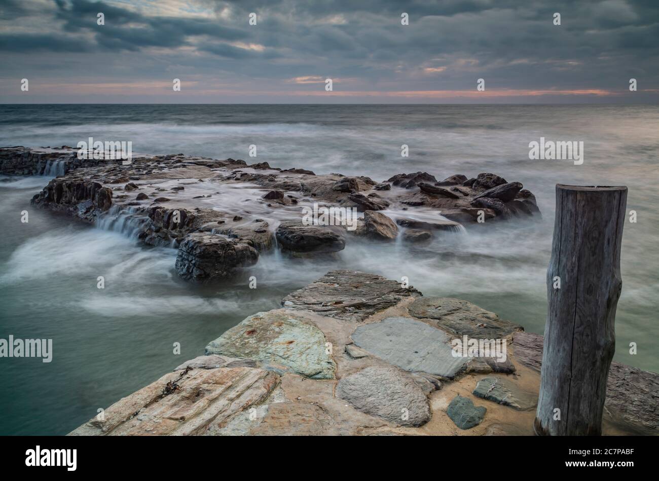 Waves topping over the harbour wall at Portwrinkle Beach in Cornwall ...