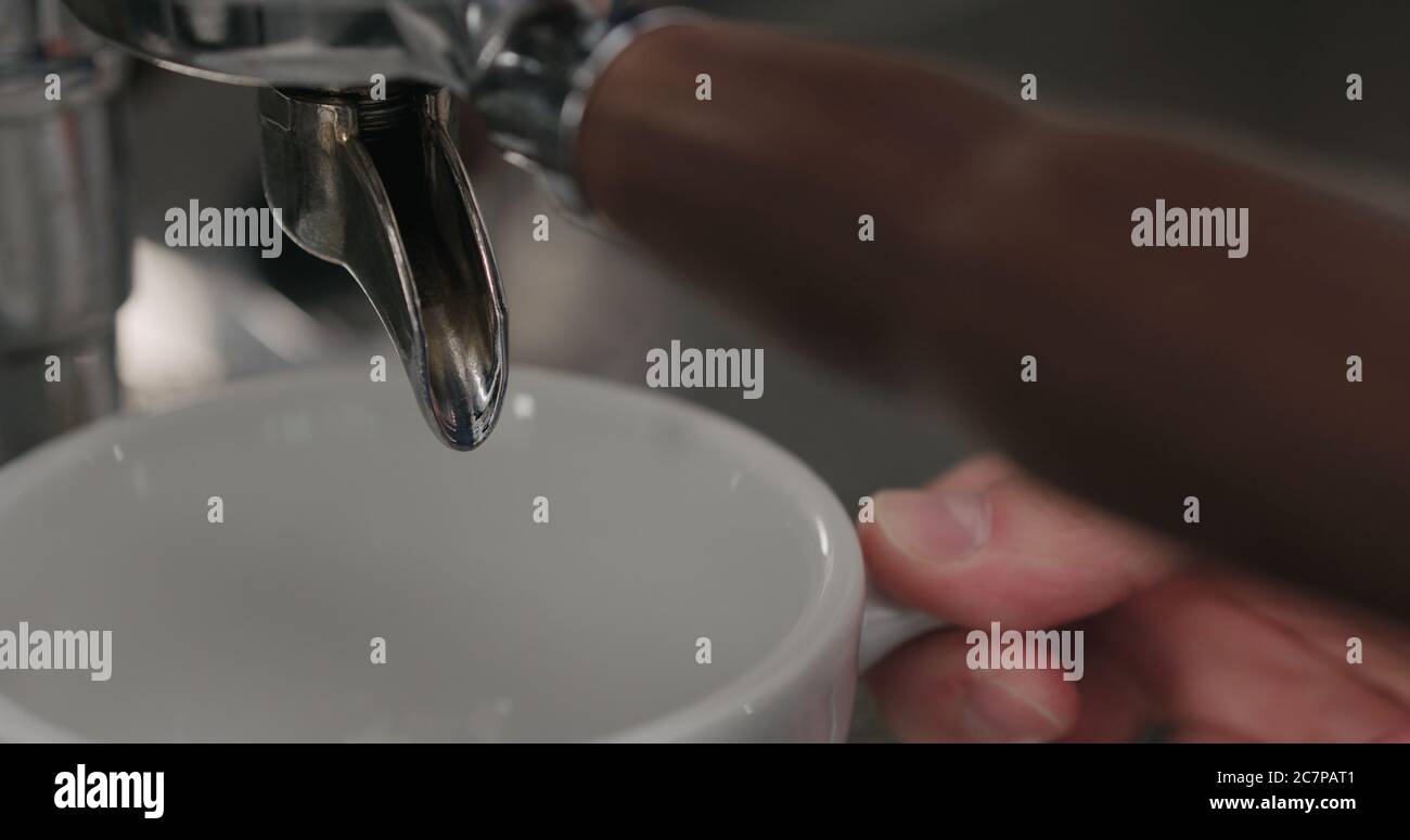 Rinse coffee machine and warming up cup before espresso pour Stock ...