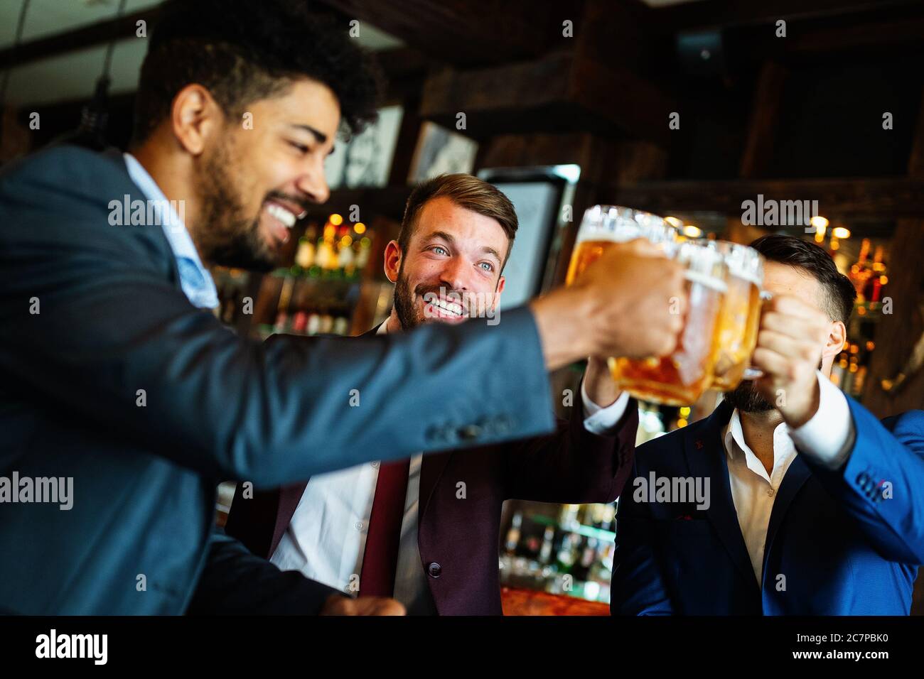 Team of colleagues socializing at the bar and drinking beers Stock ...