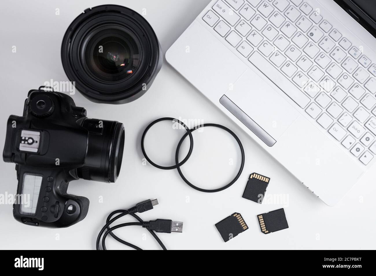 top view of dslr camera, lenses, photo equipment and laptop over white ...