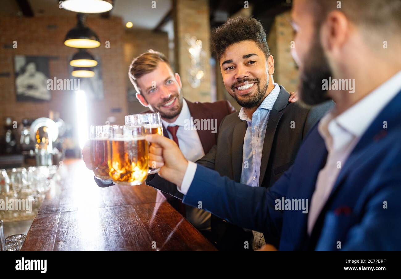 Team of colleagues socializing at the bar and drinking beers Stock ...