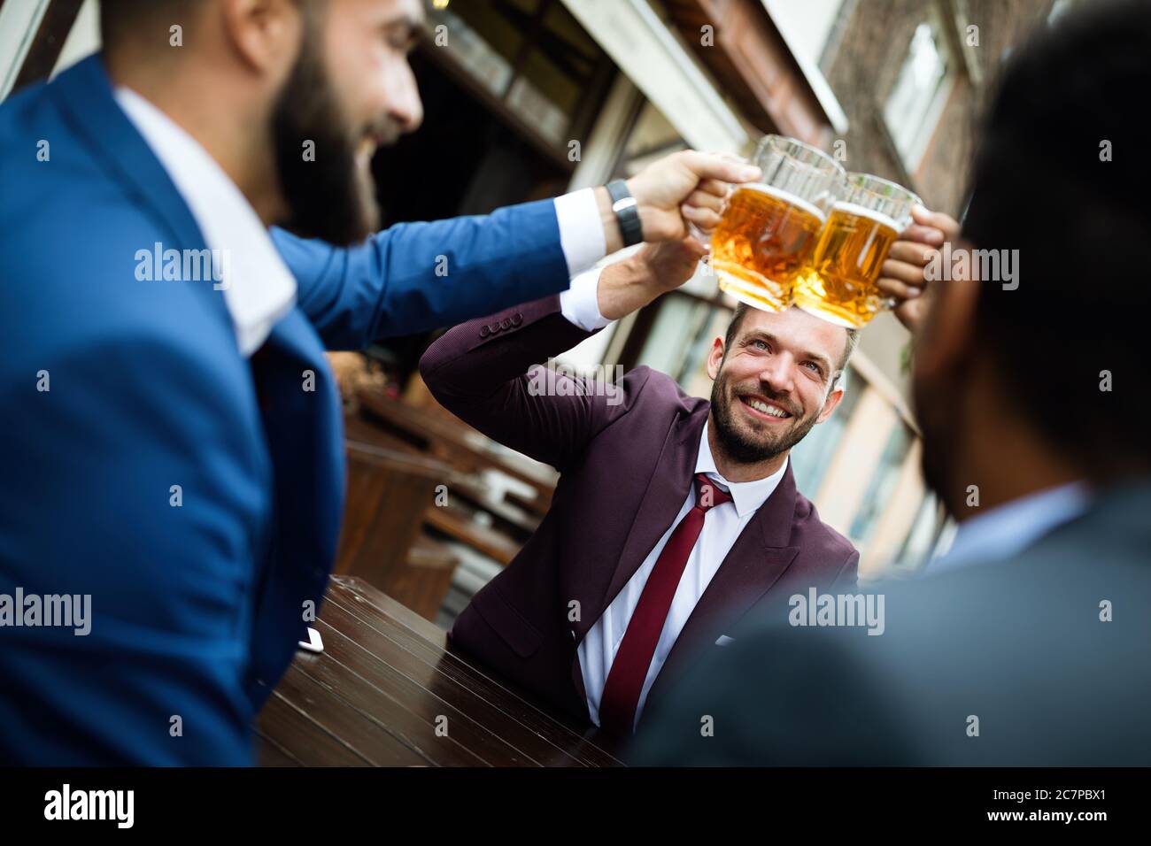 Young businessmen are drinking beer, talking and smiling while resting ...
