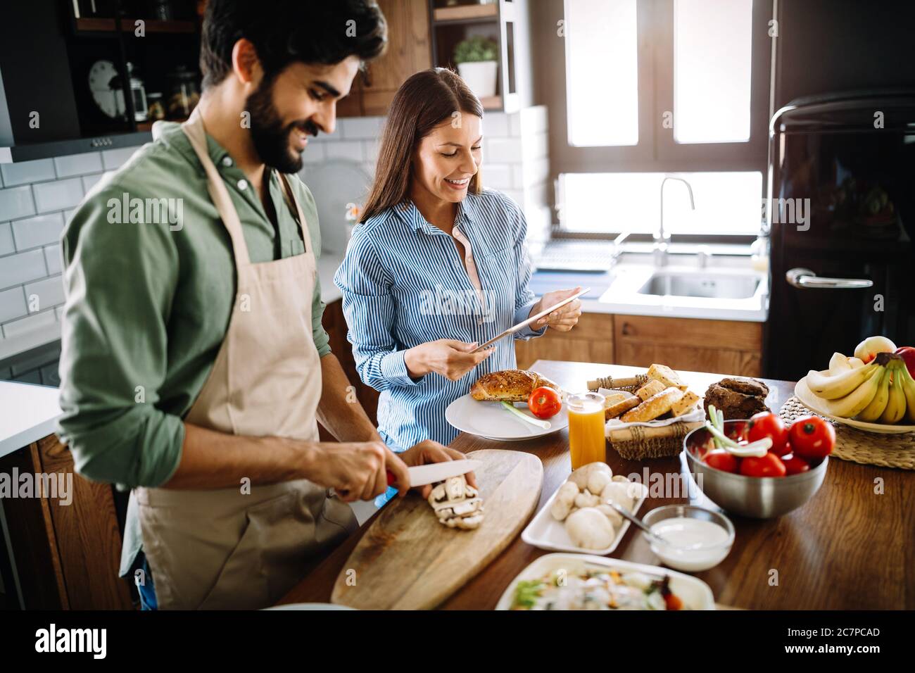 Beautiful couple in the kitchen while cooking Stock Photo - Alamy