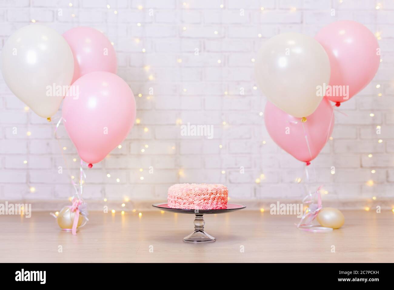 birthday celebration background - pink cream cake over brick wall with ...