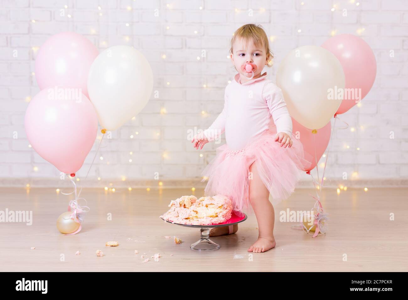 crashed party background - cute little girl and smashed cake over brick ...